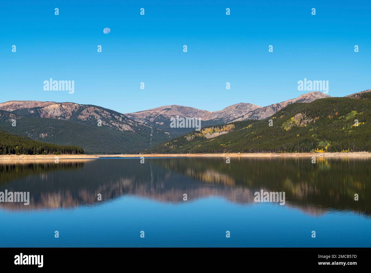Moon and High Mountain Peaks are reflected on beautiful Turquoise Lake ...