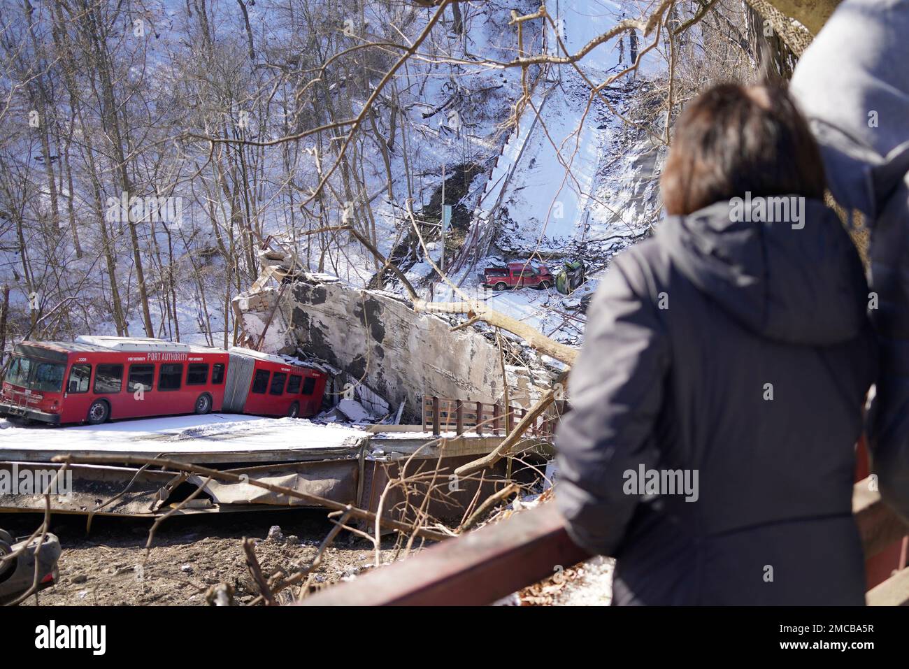 Onlookers look at the bus and vehicles below after Friday's bridge ...