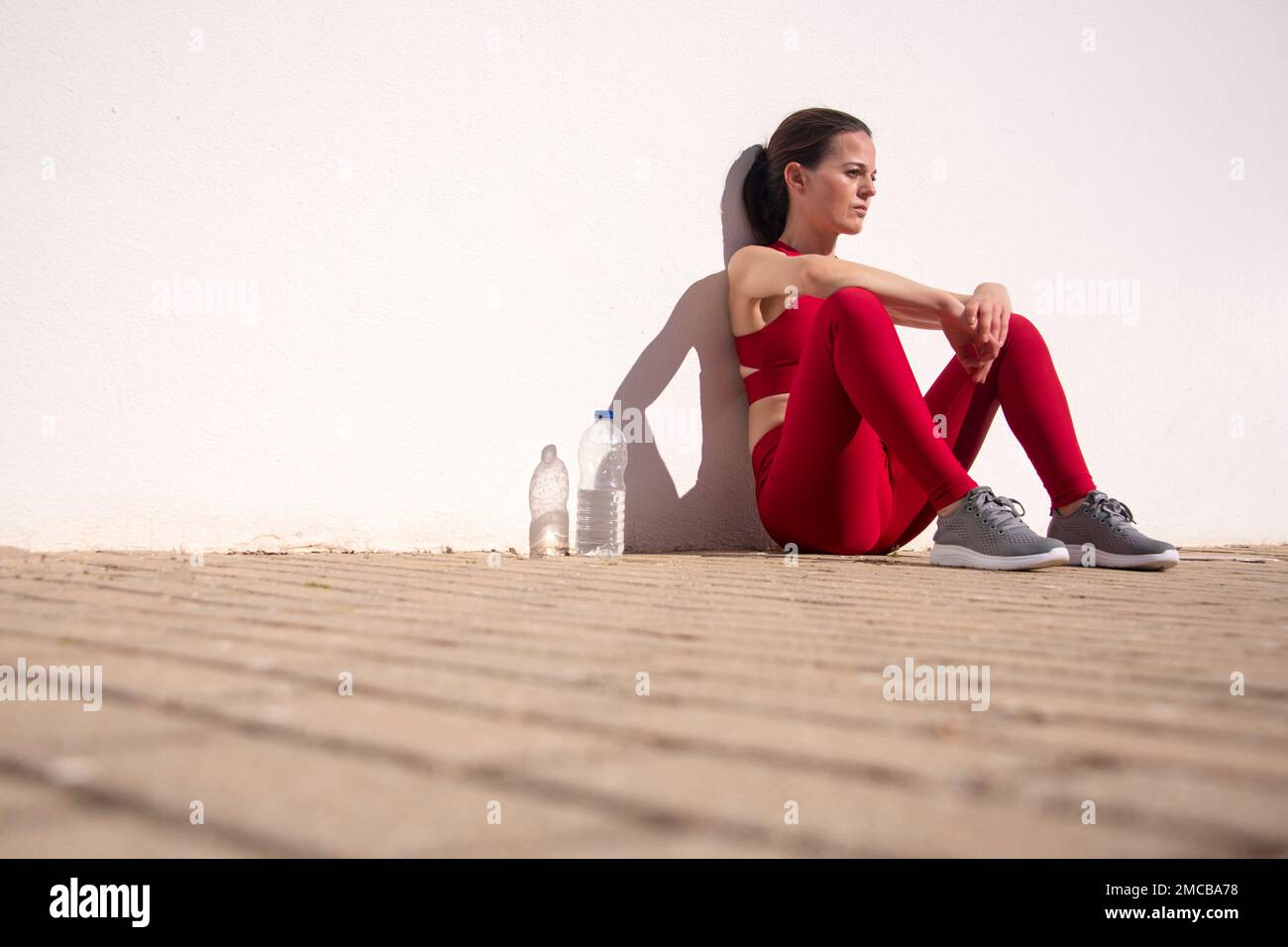 Woman sitting against white wall hi-res stock photography and images ...