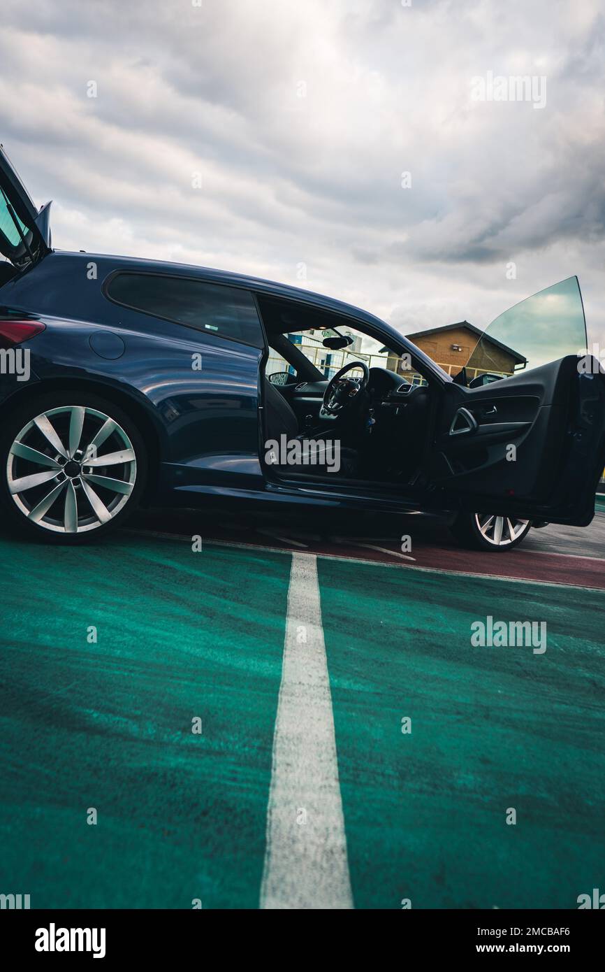 A vertical shot of an open car door and its black interior with modern ...