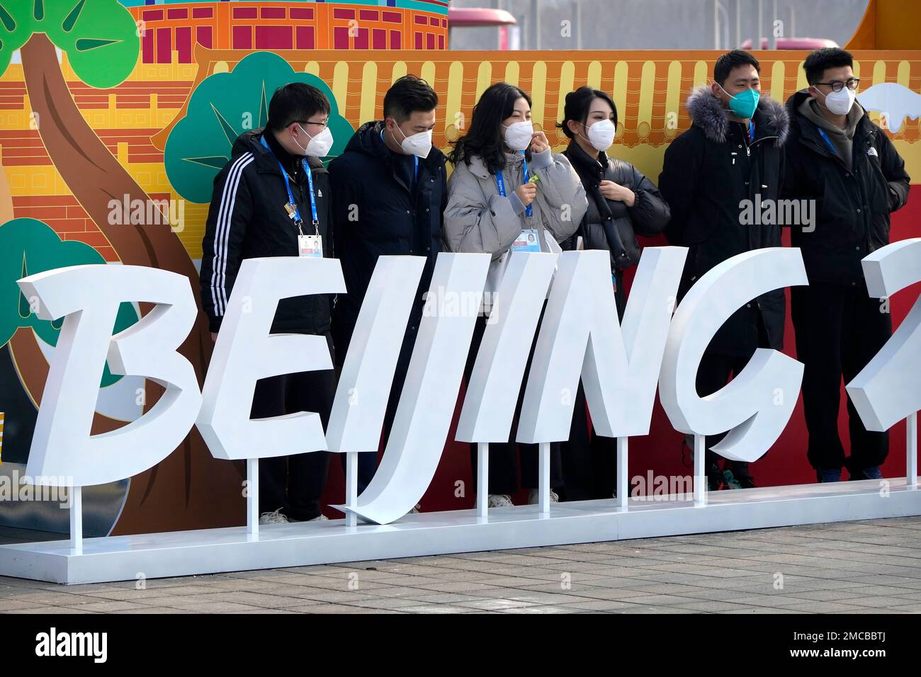 Staff members wearing face masks pose for a group photo with a Beijing ...