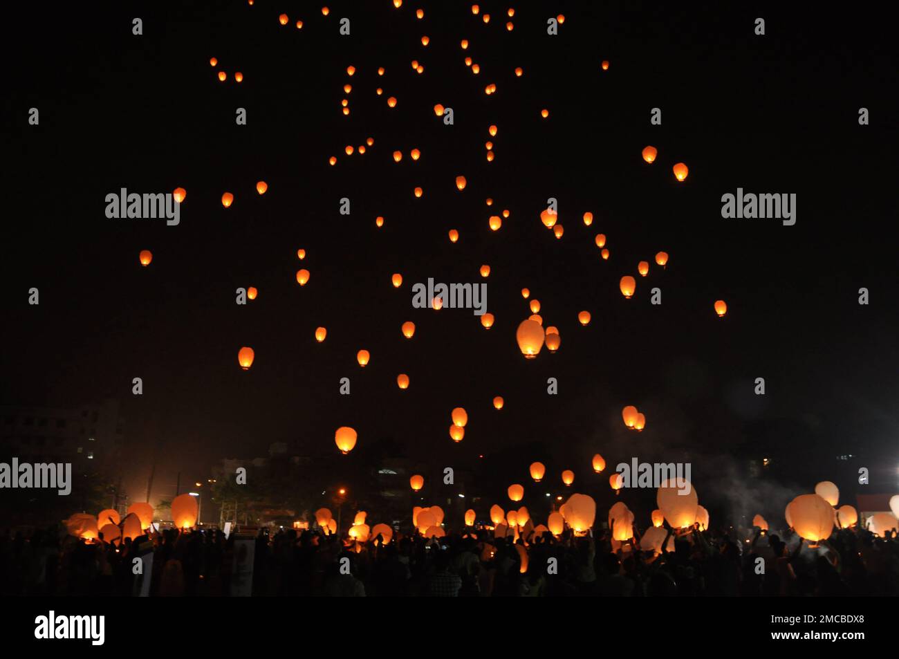 Mesmerizing view of lots of people launching sky lanterns flying in the ...