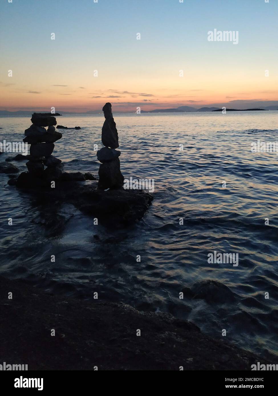 A shore full of rocks and a deep blue sea during scenic sunset, Greece ...