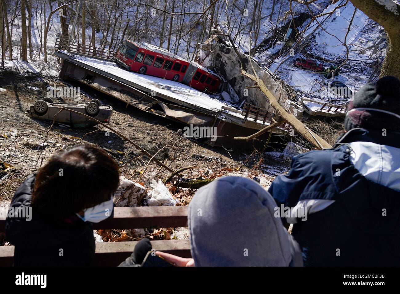 Onlookers look at the bus and vehicles below after Friday's bridge ...