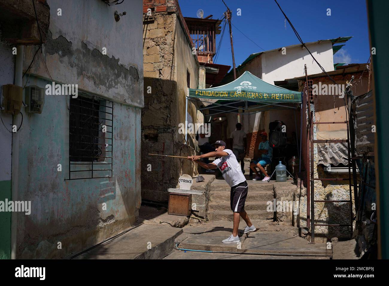 A man takes a swing while playing the traditional game of "chapitas" or ...