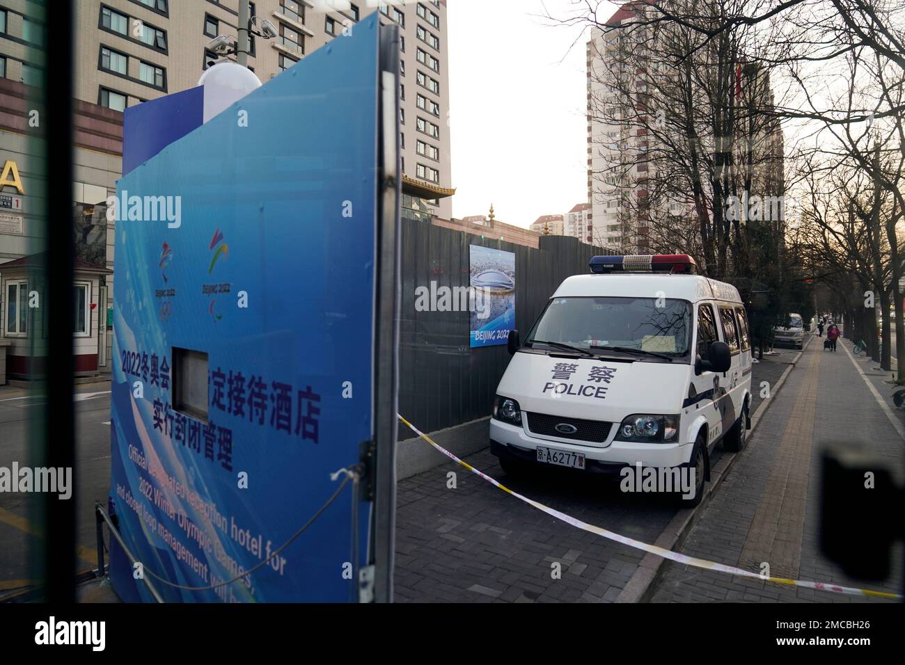 A police vehicle is parked outside a media hotel walled in by fences as ...