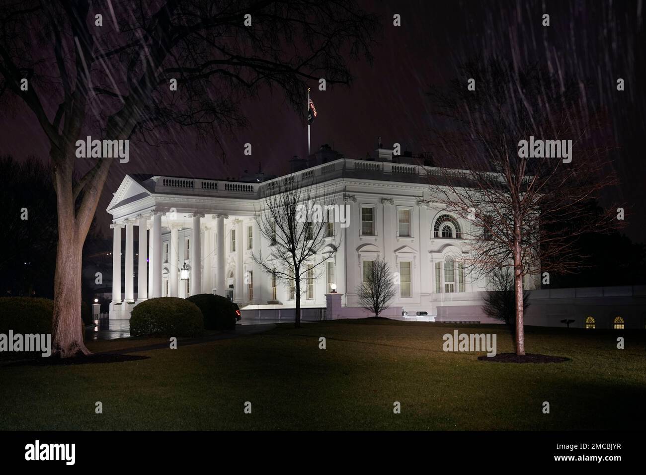 In this photo made with a slow shutter speed, light rain falls outside ...