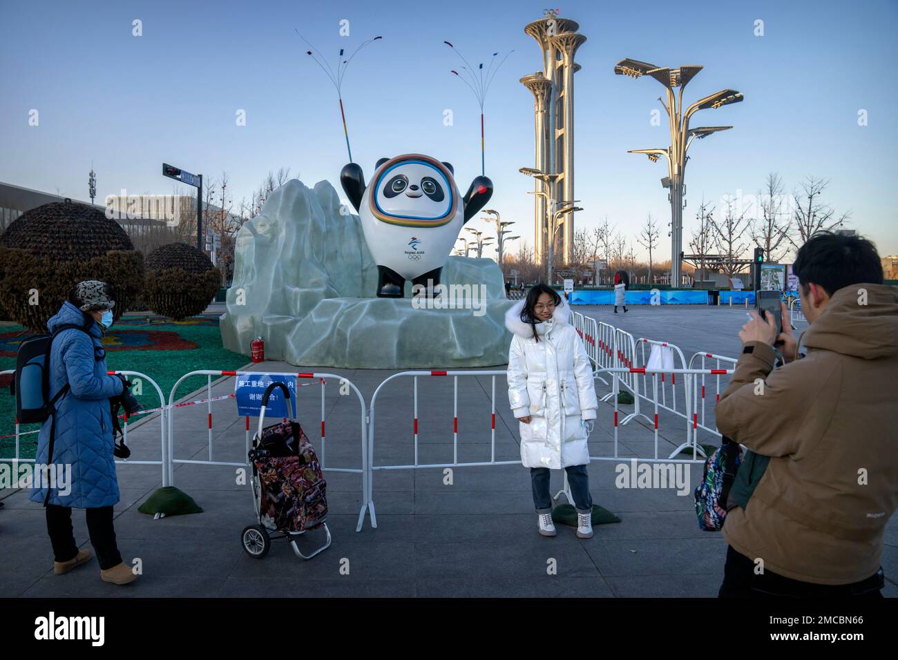 A woman poses for a photo with a statue of the Winter Olympics mascot ...