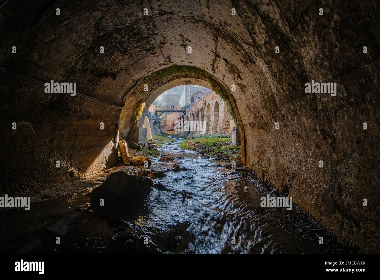 Exit from vaulted sewer tunnel. Underground river, view from inside of ...