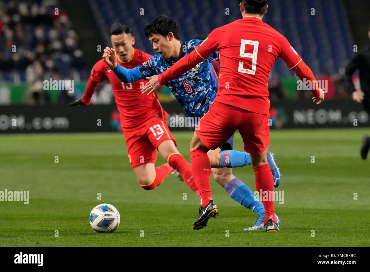 Japan's Wataru Endo, center, fights for the ball against China's Zhang ...