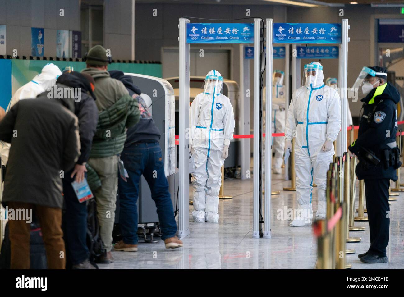 Olympic workers in protective gear work at a security check point at a ...