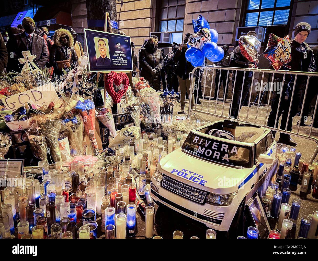A vigil is held around a makeshift memorial outside the 32nd precinct ...