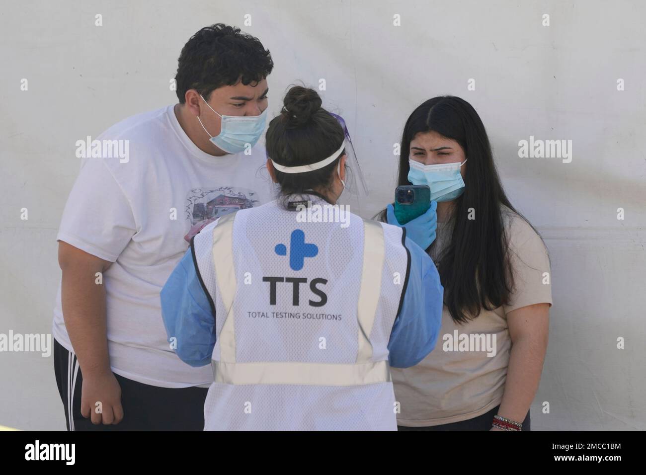 A worker checks in two people at a COVID-19 testing site Wednesday, Jan ...