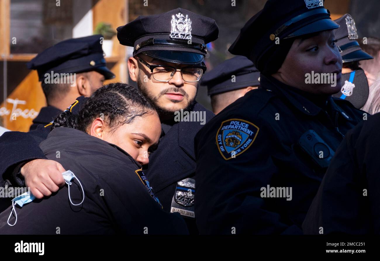 Police officers embrace after the remains of New York City Police ...
