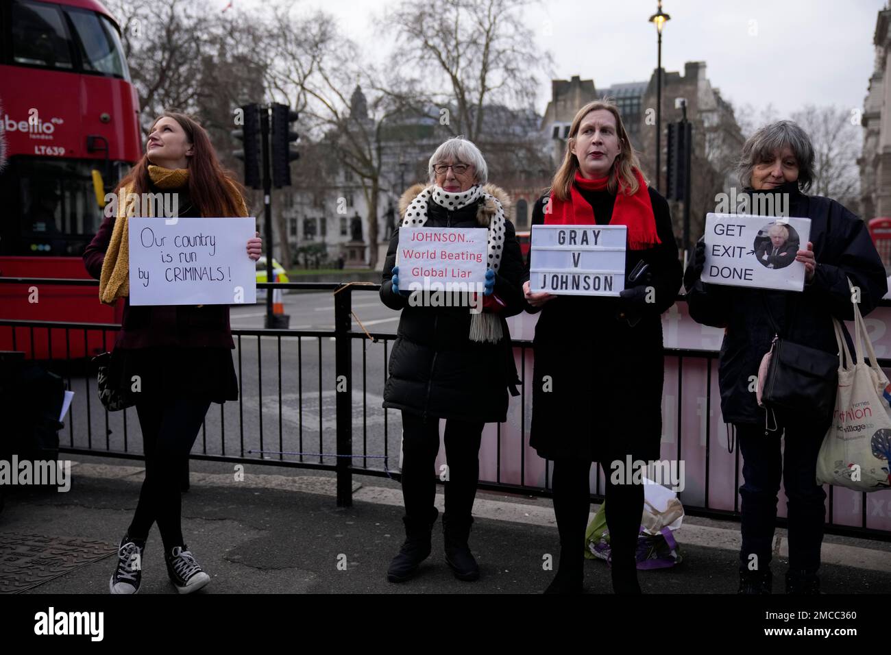 Anti-Boris Johnson protesters hold placards by Parliament Square, in ...