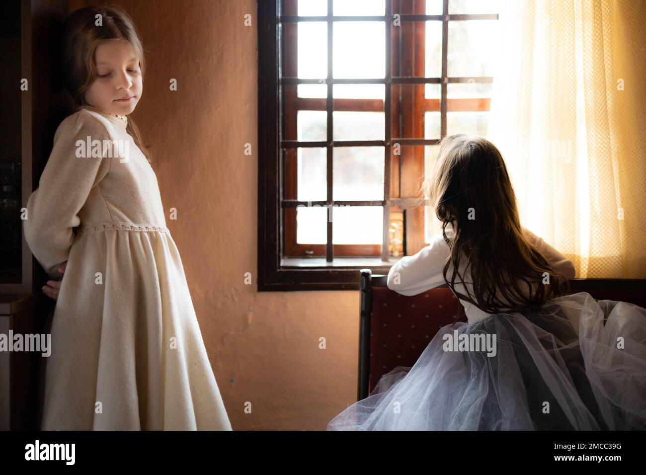 Little girls in white vintage dresses inside a countryside cabin Stock ...
