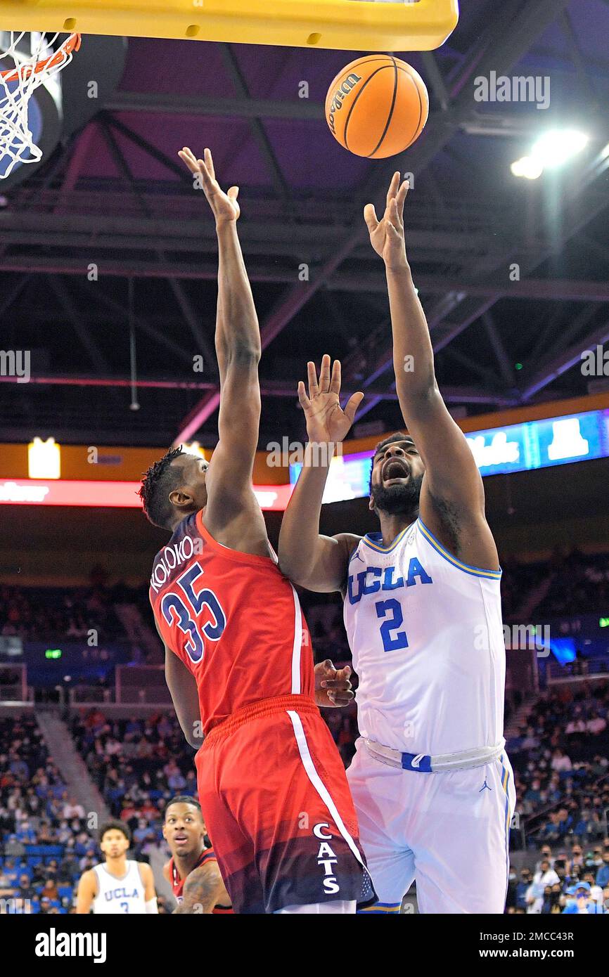 UCLA forward Cody Riley, right, shoots as Arizona center Christian ...