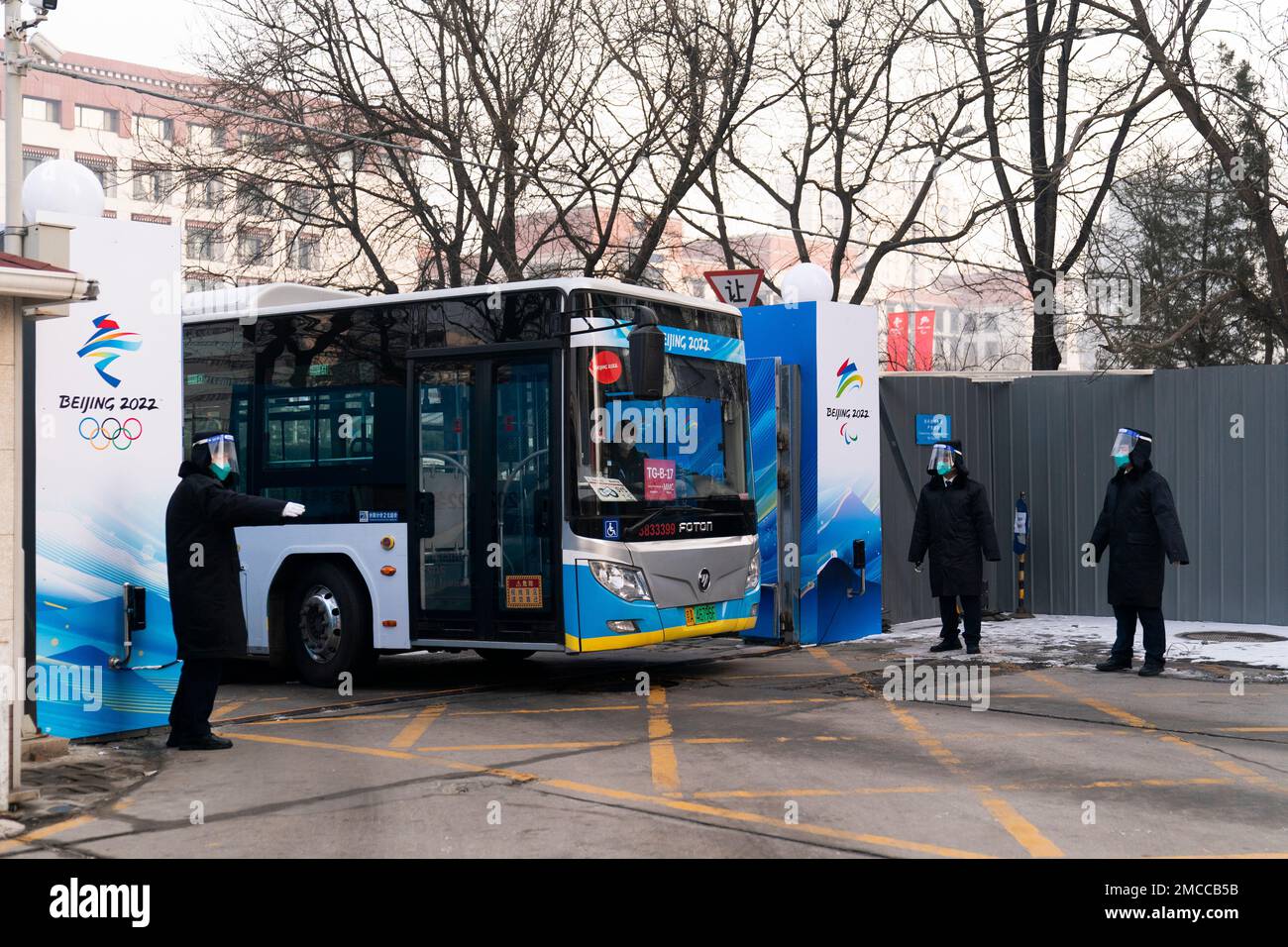 Security guards watch as an Olympic shuttle bus pulls into a hotel ...