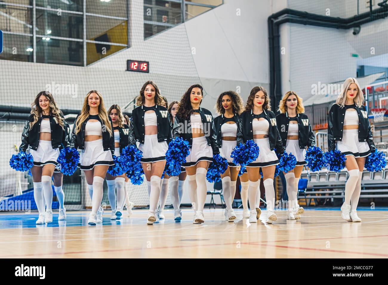 A group of cheerleaders in uniforms walking towards towards the camera ...