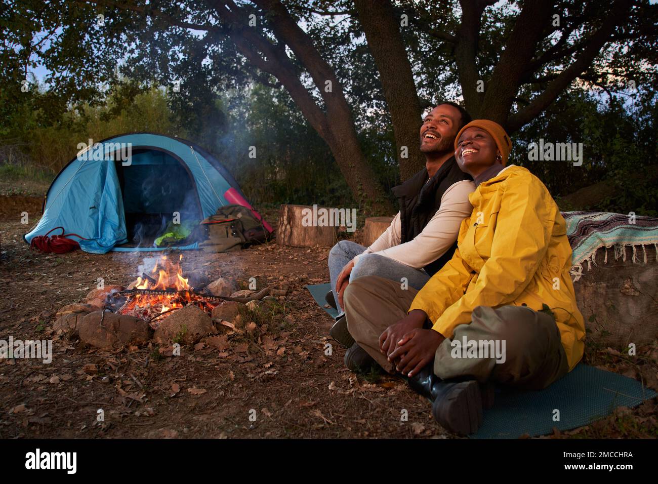 African couple spending free time and sitting during camping together ...