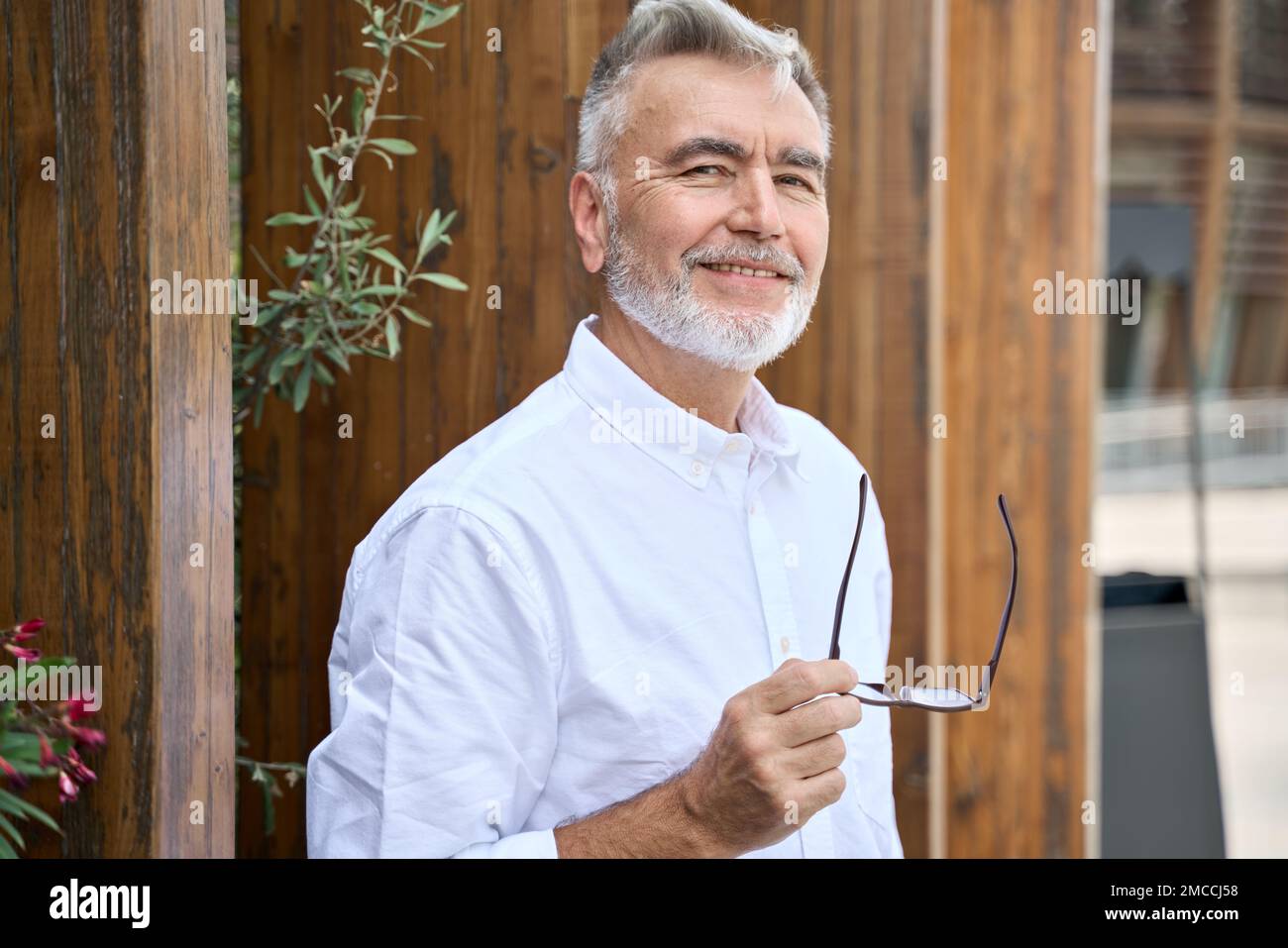 Smiling classy older senior business man looking at camera standing ...