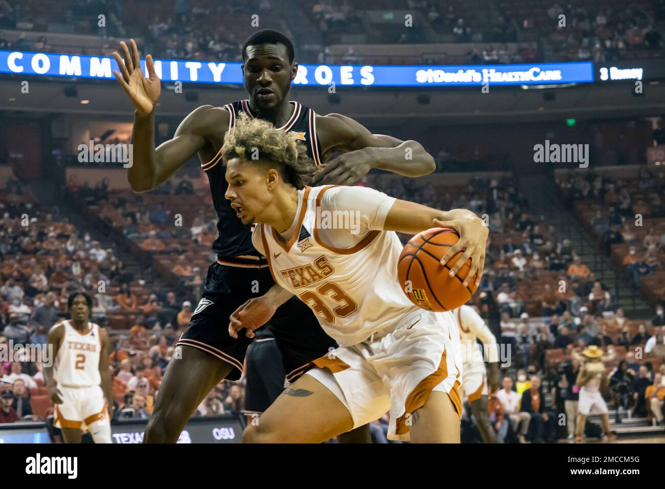 Texas forward Tre Mitchell, front, drives around Oklahoma State forward ...