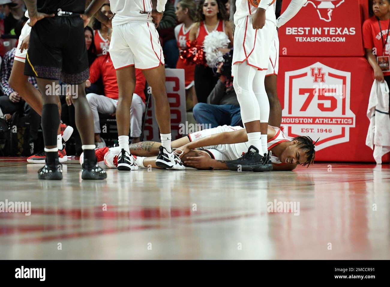 Houston guard Ramon Walker Jr. holds his knee after falling during the ...