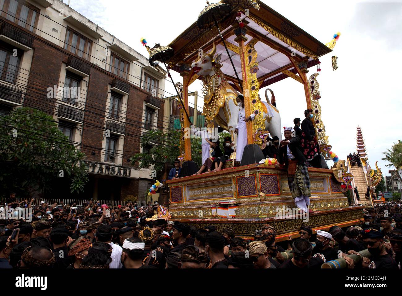 A crowd of people watch a giant sarcophagus in the form of a bull ...