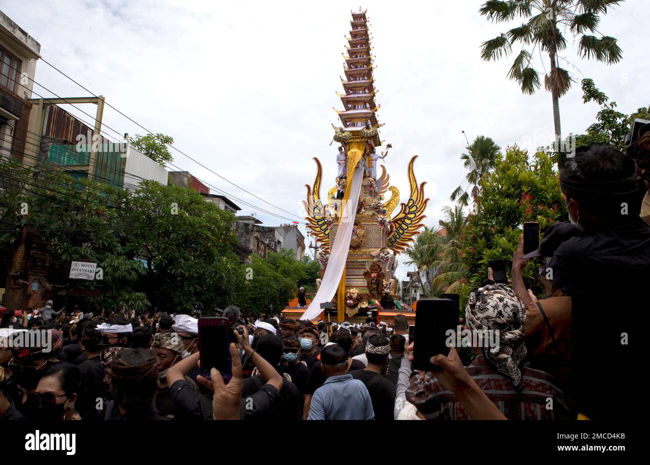 A crowd of people watch men carry an eleven-story cremation tower which ...