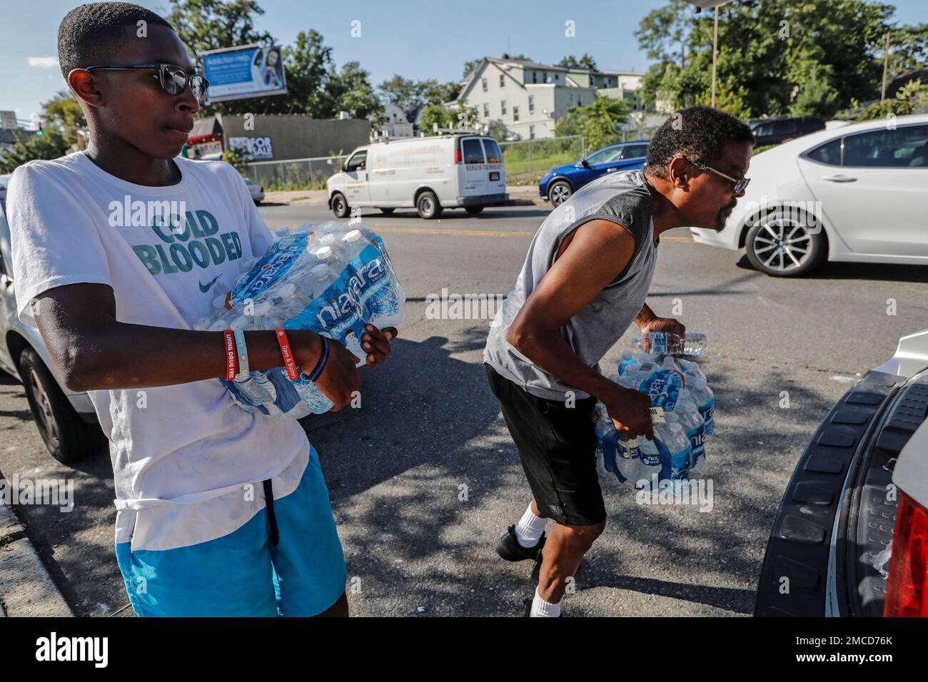 FILE- Volunteer Matthew Tiggs, left, helps Newark resident Mack Mayton ...