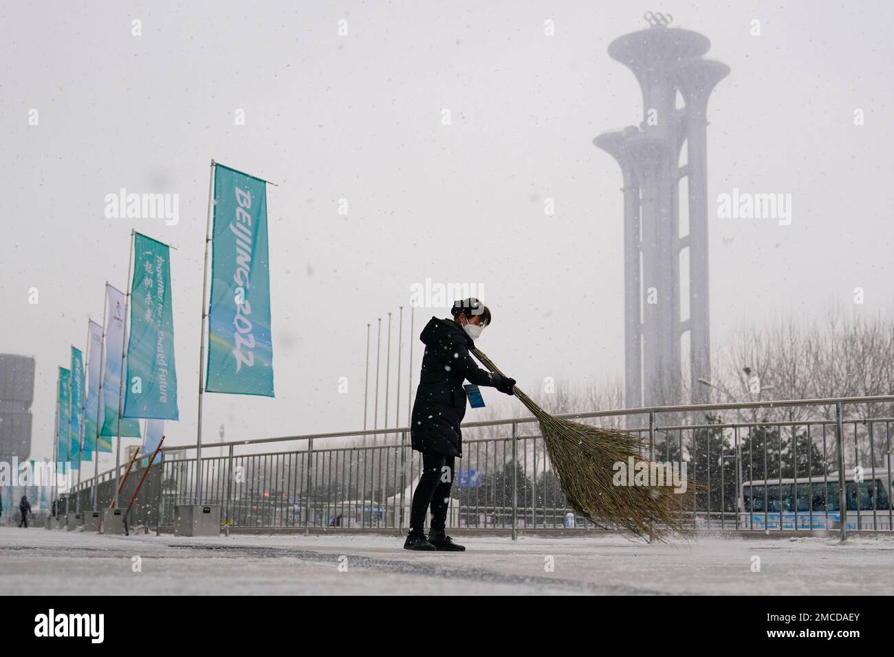 Workers sweep snow off of walkways outside the main media center at the ...