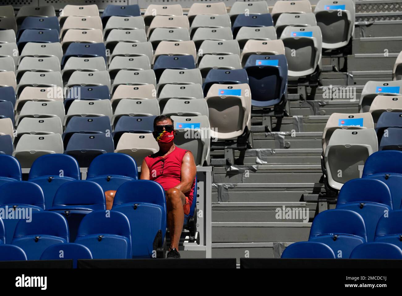 A masked spectator watches the second round match between Iga Swiatek of Poland and Rebecca ...