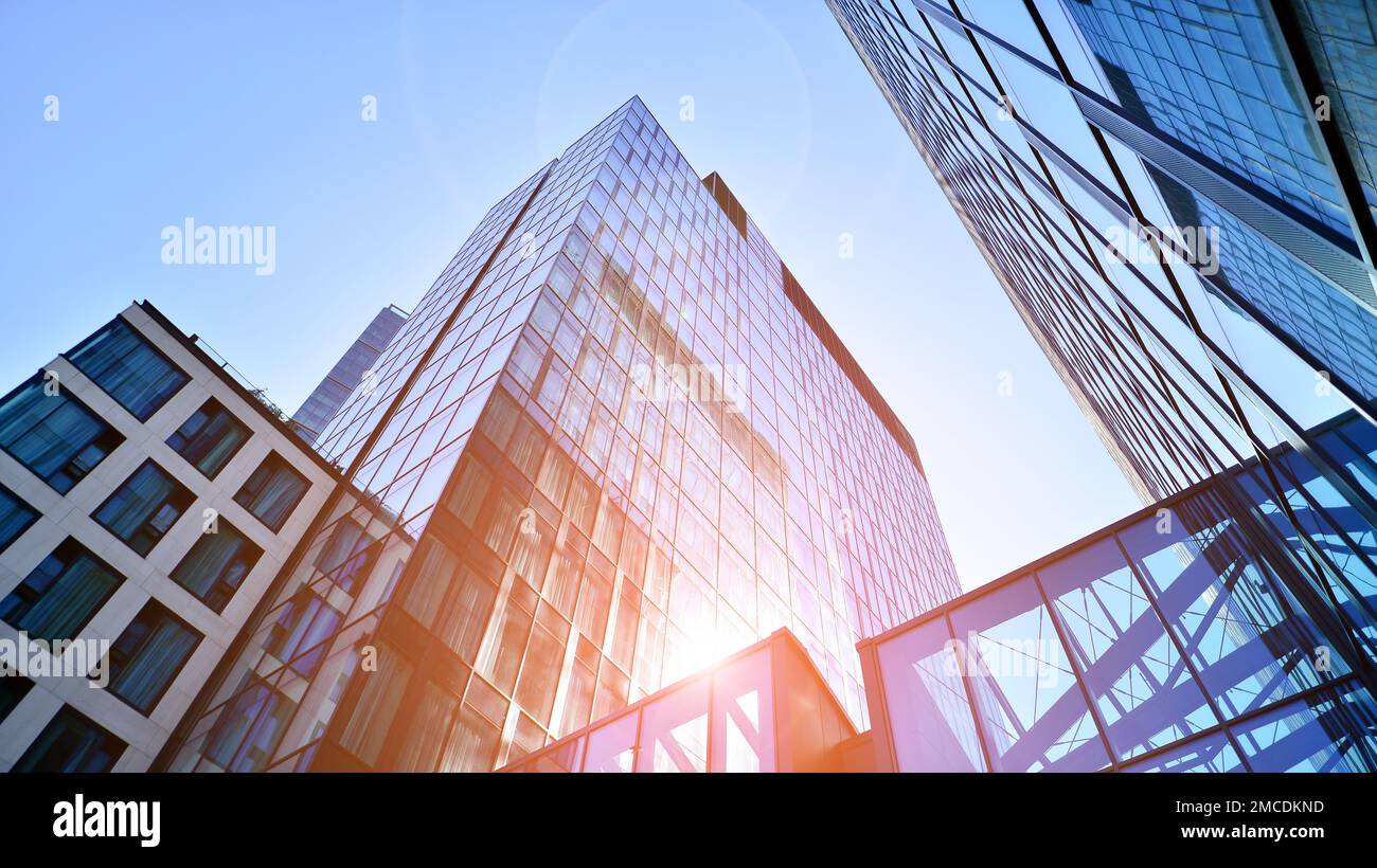 Bottom view of modern skyscraper in business district against blue sky ...