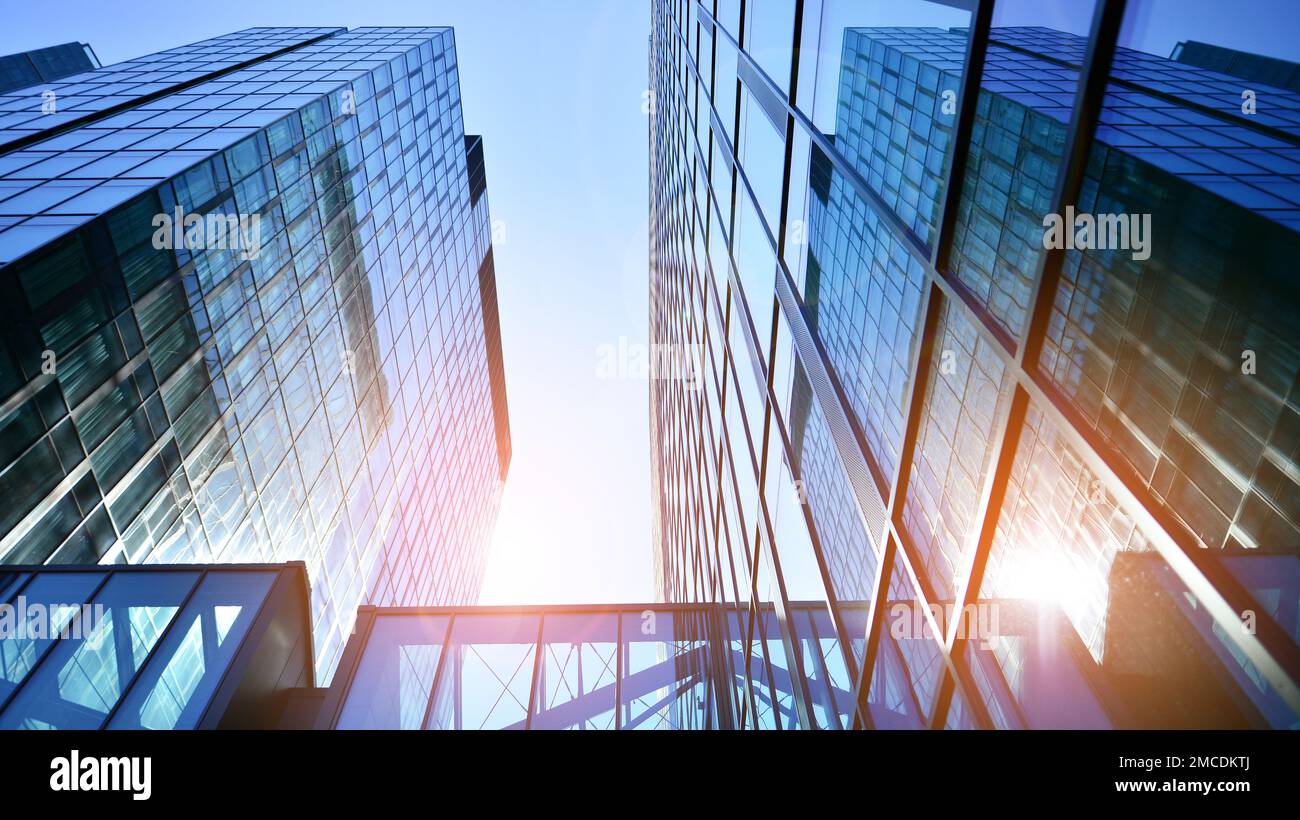 Bottom view of modern skyscraper in business district against blue sky ...