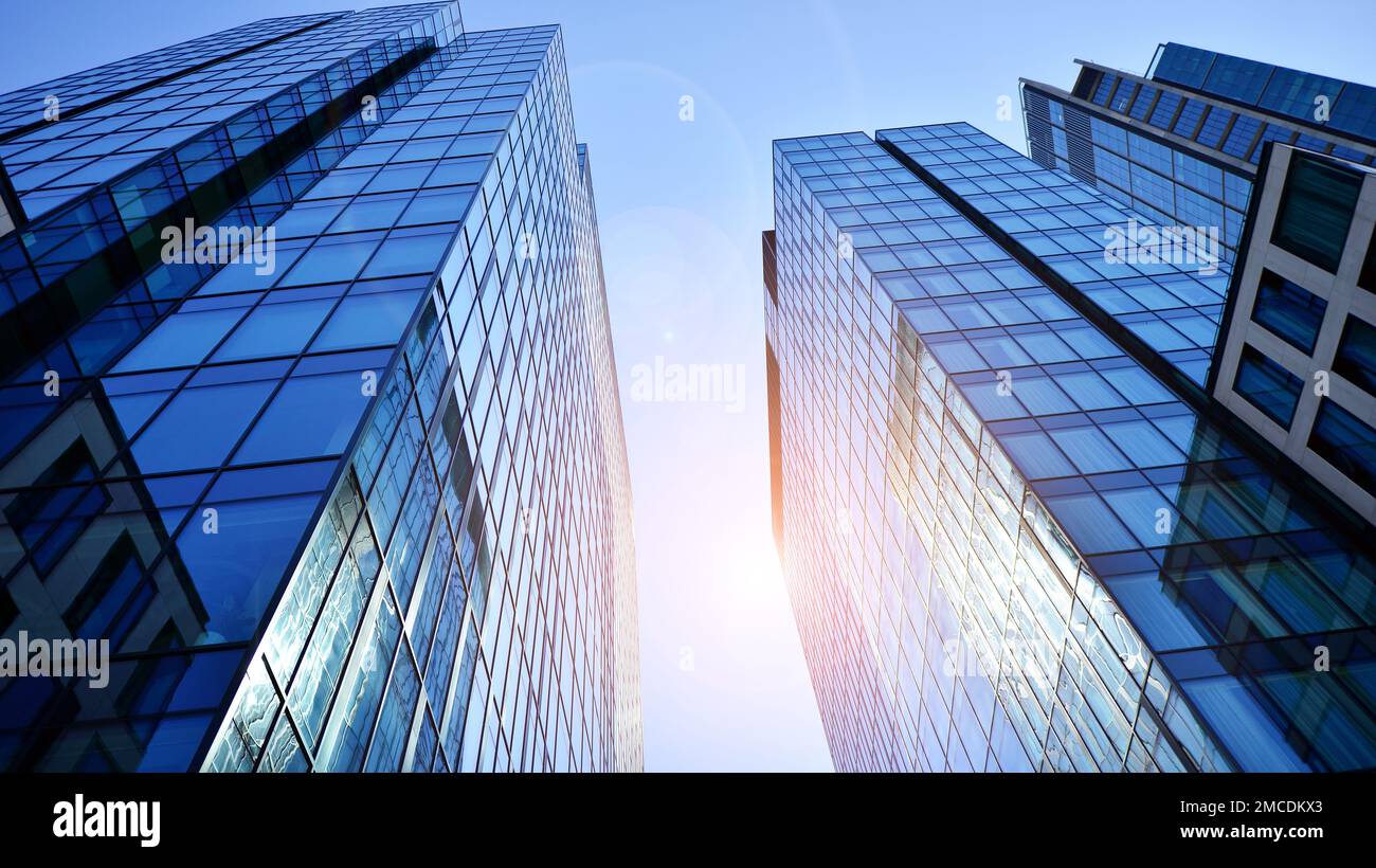 Bottom view of modern skyscraper in business district against blue sky ...