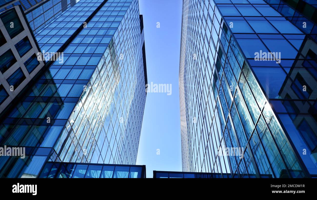 Bottom view of modern skyscraper in business district against blue sky ...