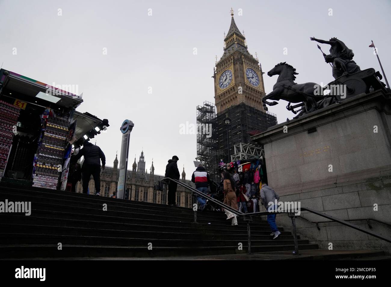 Tourists visit memorabilia stalls in the shadow of the Queen Elizabeth ...