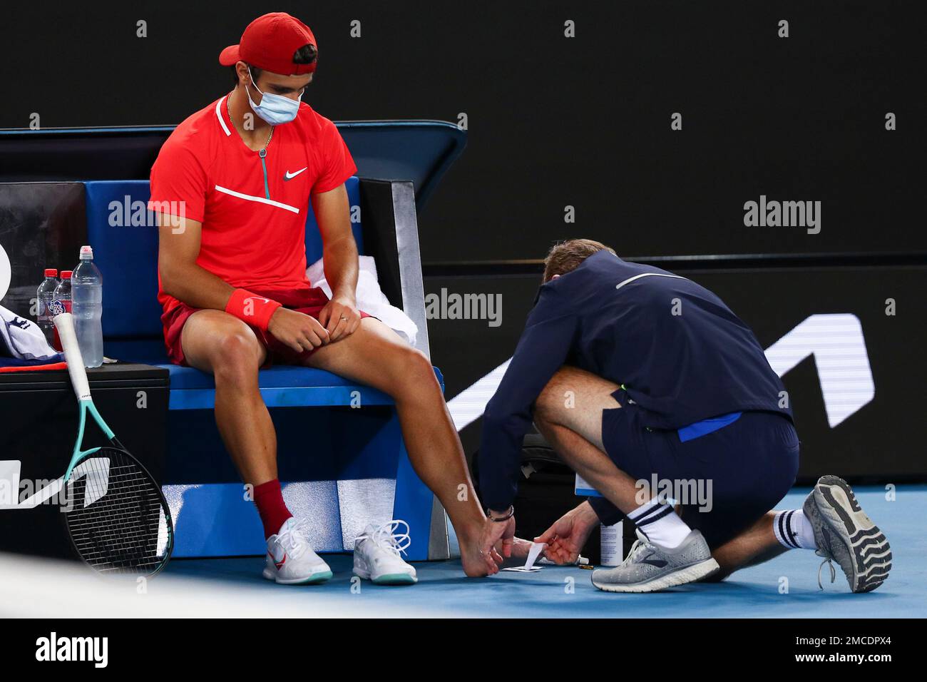Lorenzo Musetti of Italy receives treatment for a foot injury during ...