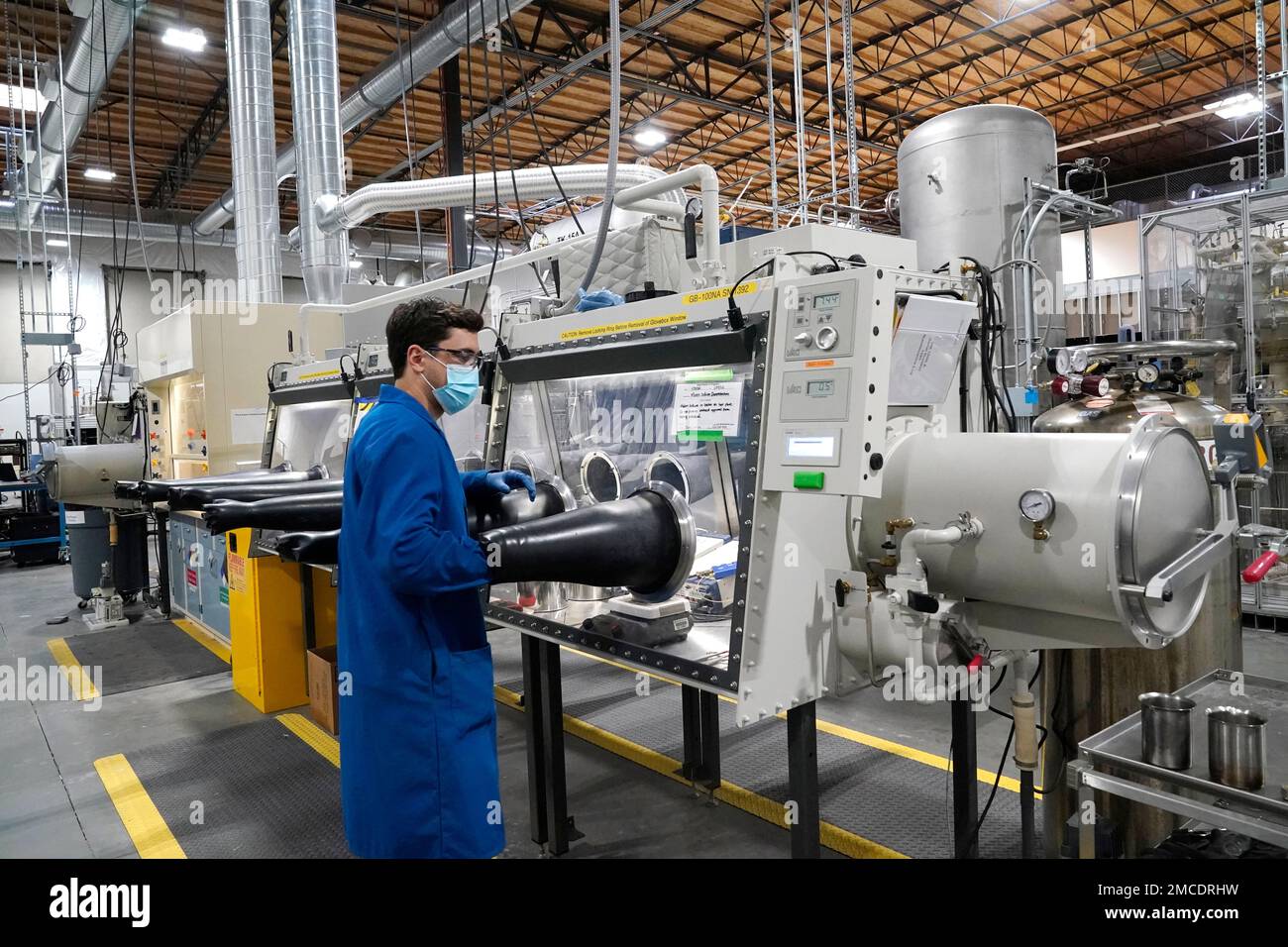 Test engineer Jacob Wilcox pulls his arm out of a glove box used for ...