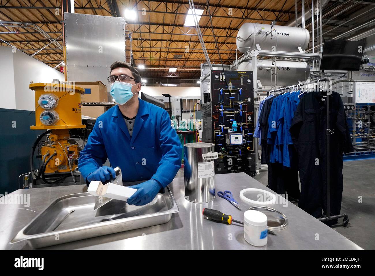 Test engineer Jacob Wilcox displays an ingot of sodium metal after ...