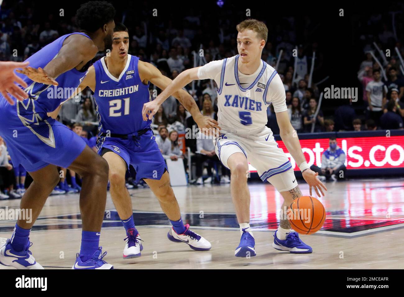Xavier's Adam Kunkel (5) dribbled as Creighton's Rati Andronikashvili ...