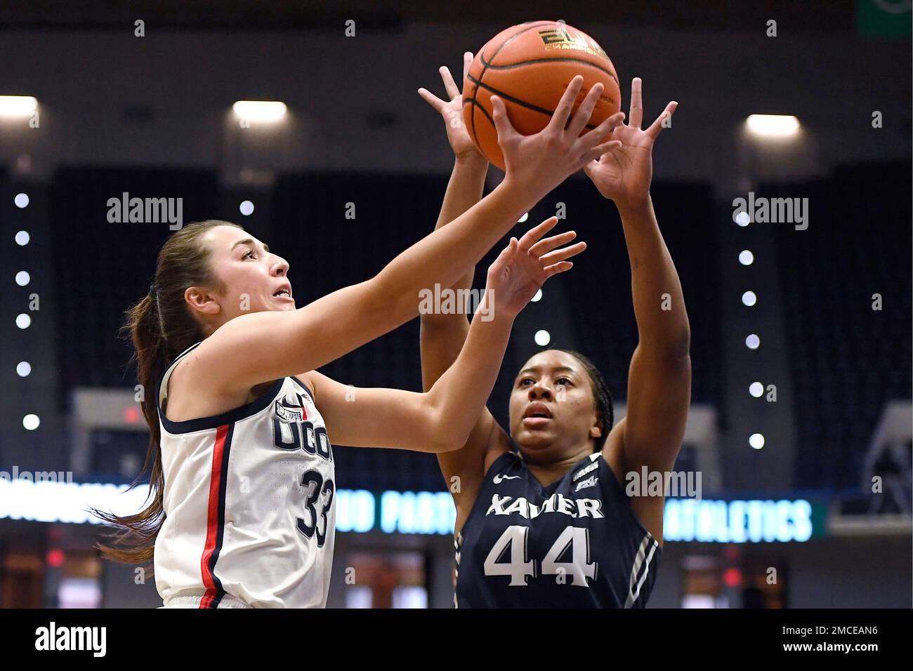 Connecticut's Caroline Ducharme (33) shoots as Xavier's Ayanna Townsend ...