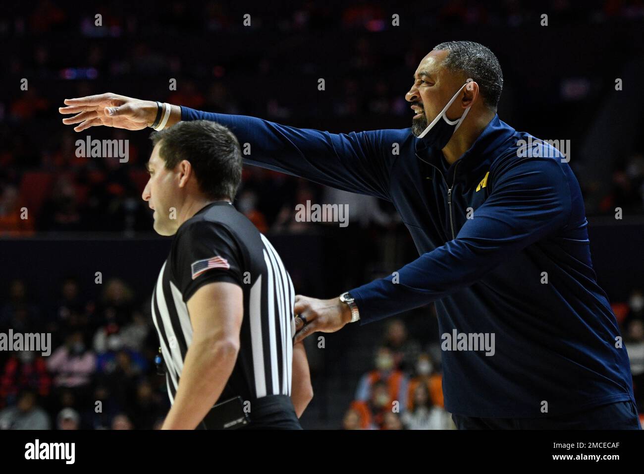 Michigan's coach Juwan Howard, right, grabs the arm of referee Kelly ...