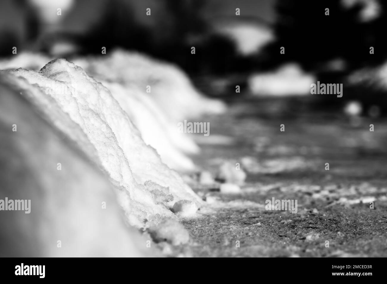 Selective focus ground level view of snow blown sidewalk section with ...