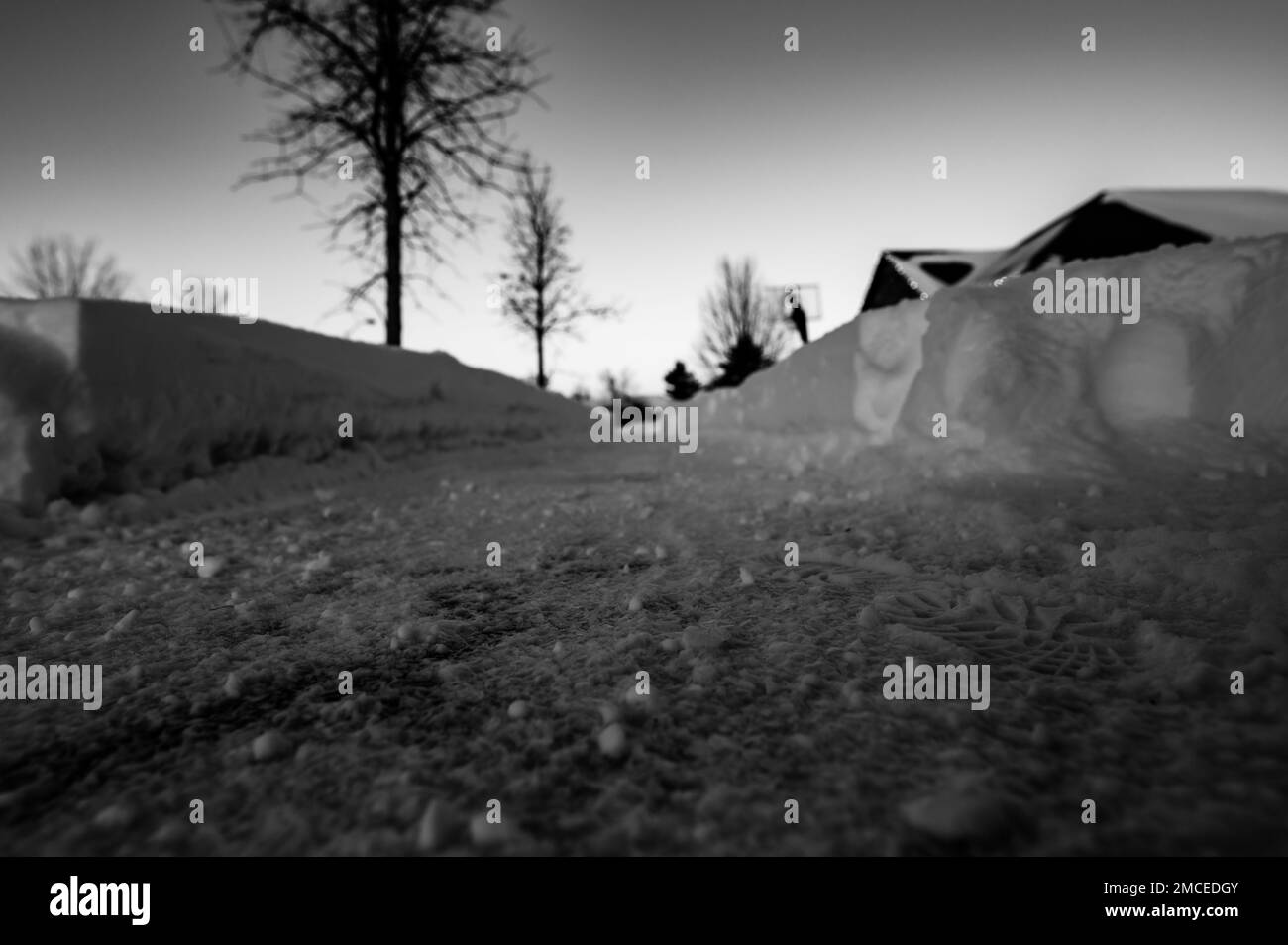 Selective focus ground level view of snow blown sidewalk section with ...