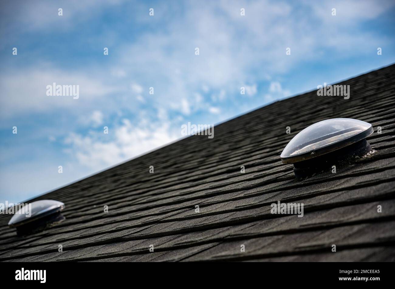 Dome shaped solar tube skylight on asphalt shingle roof Stock Photo - Alamy