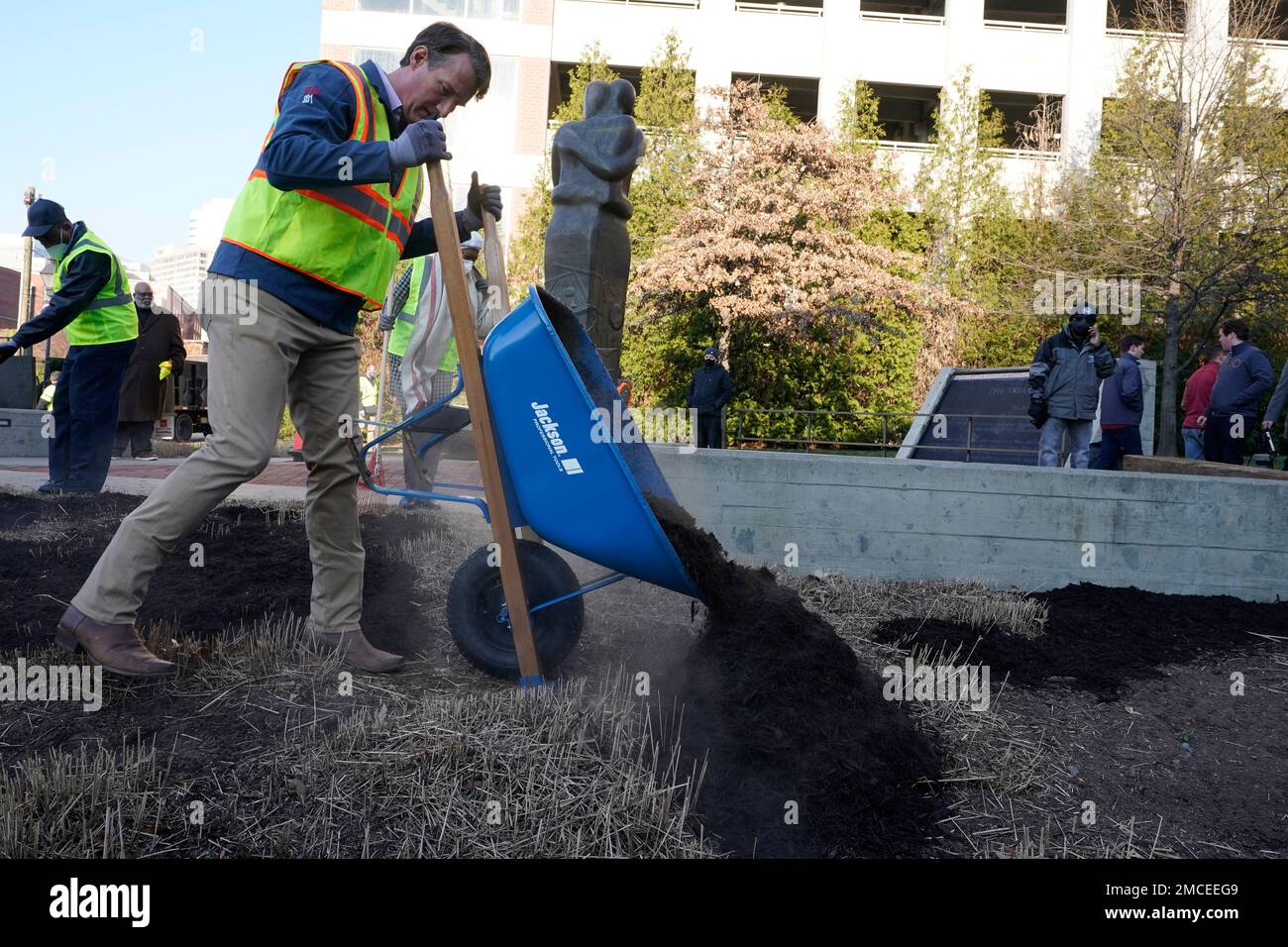 Virginia Gov.-elect Glenn Youngkin works spreading mulch at the site of ...