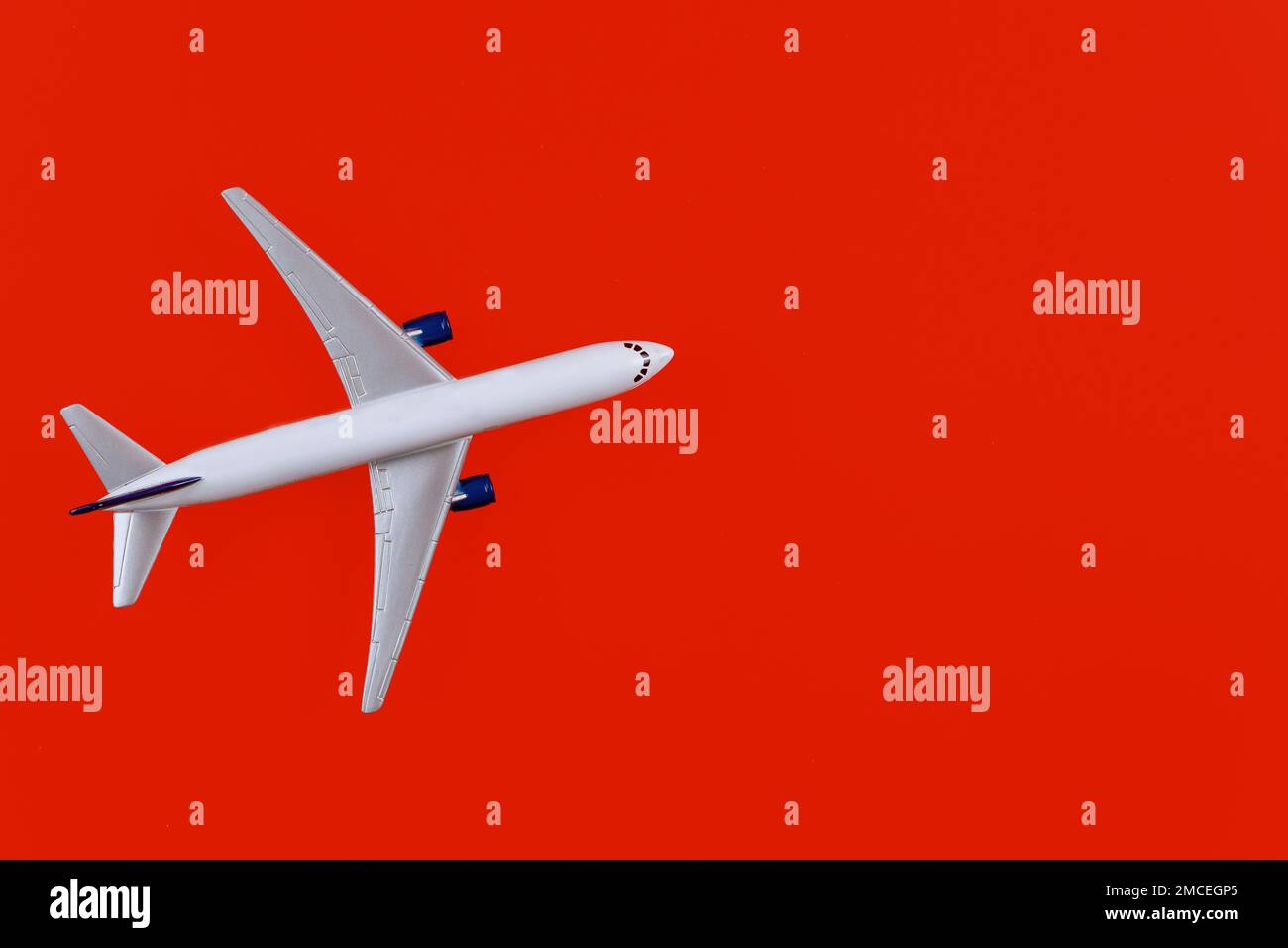 Airplane model white plane on red background Stock Photo - Alamy