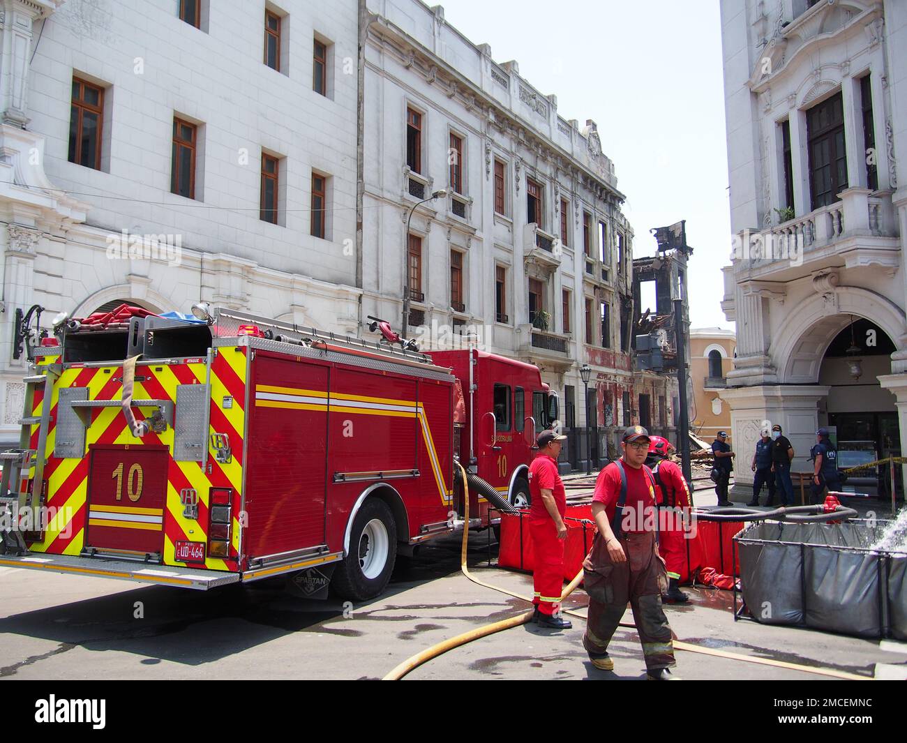 Fire truck spraying water on the ruins of the Marcionelli building that ...