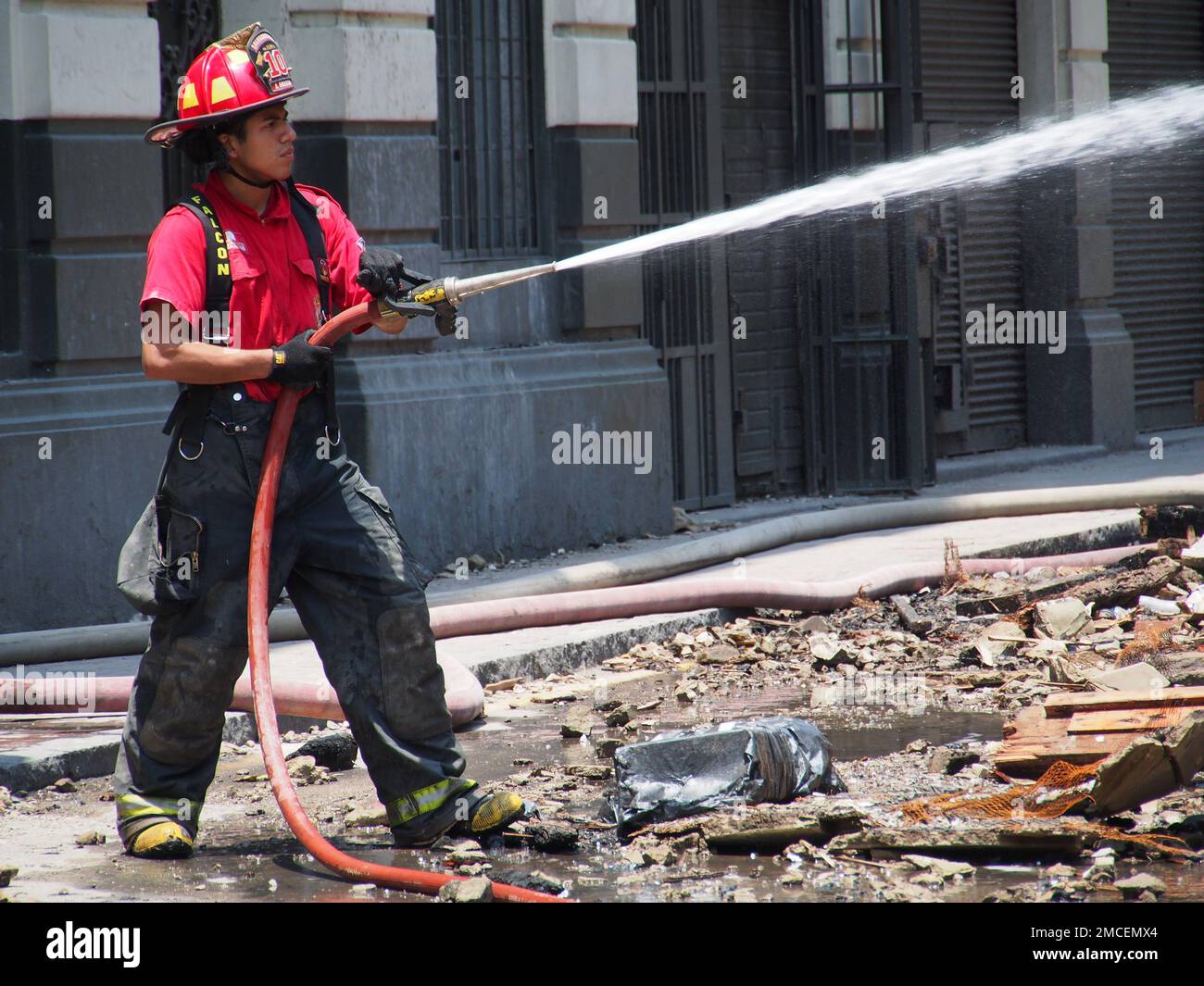 Firefighter spraying water to ruins of the Marcionelli building that ...